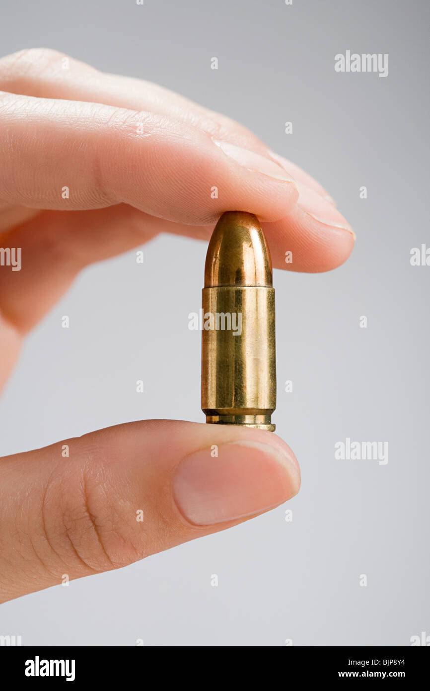 Person holding a bullet Stock Photo - Alamy