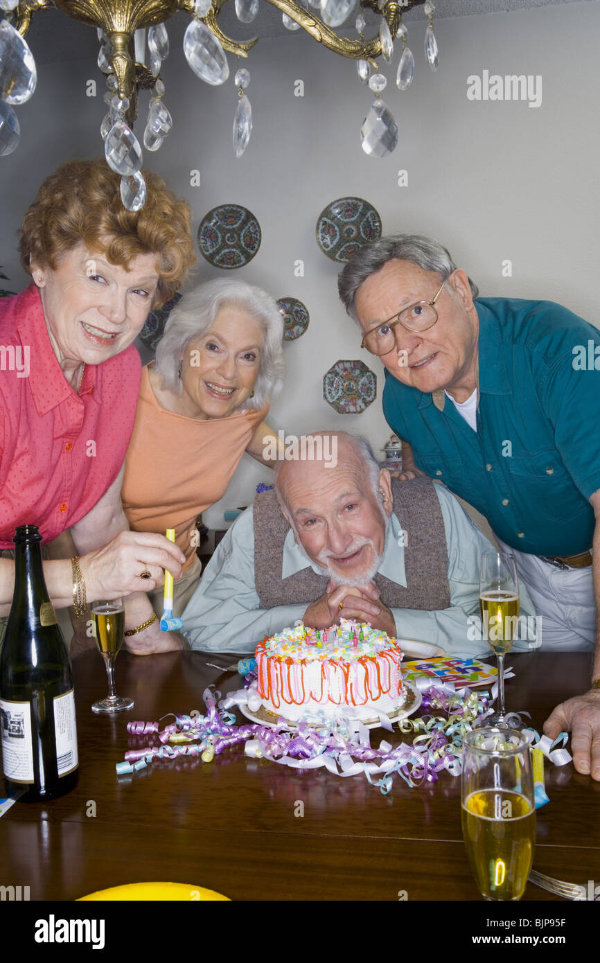 Partygoers around a birthday cake Stock Photo - Alamy