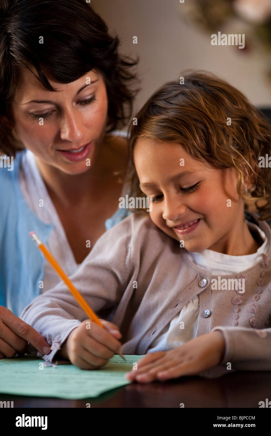 Woman and daughter writing Stock Photo - Alamy
