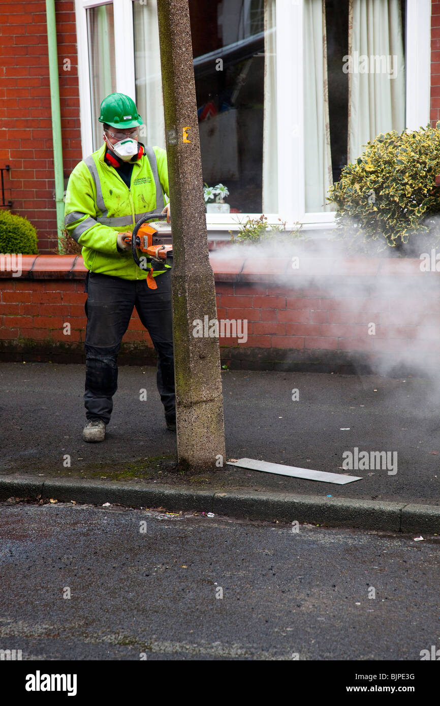 Council worker cutting down a concrete lamp post Stock Photo - Alamy