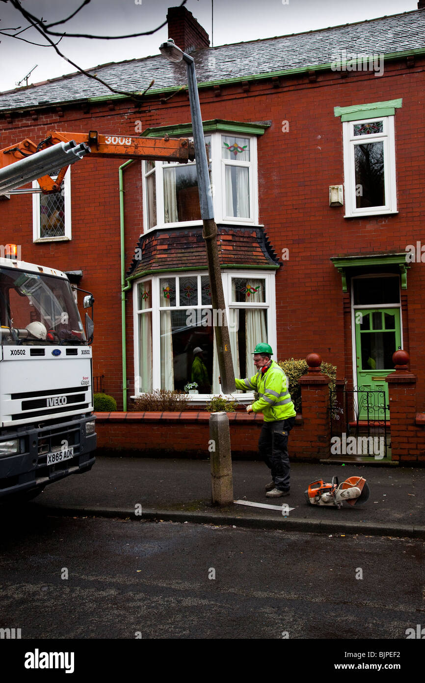 Council worker cutting down a concrete lamp post Stock Photo - Alamy