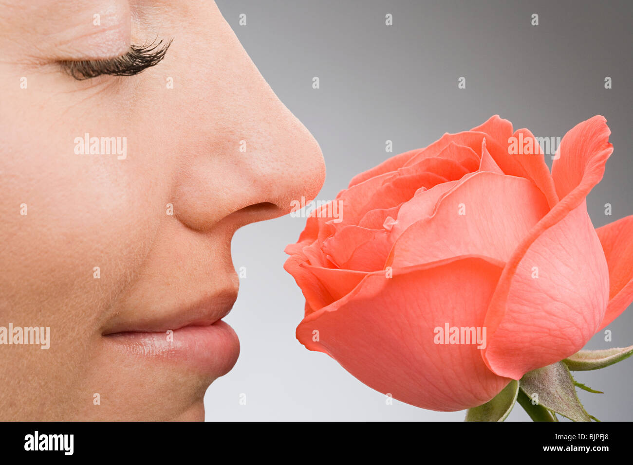 A woman smelling a rose Stock Photo - Alamy