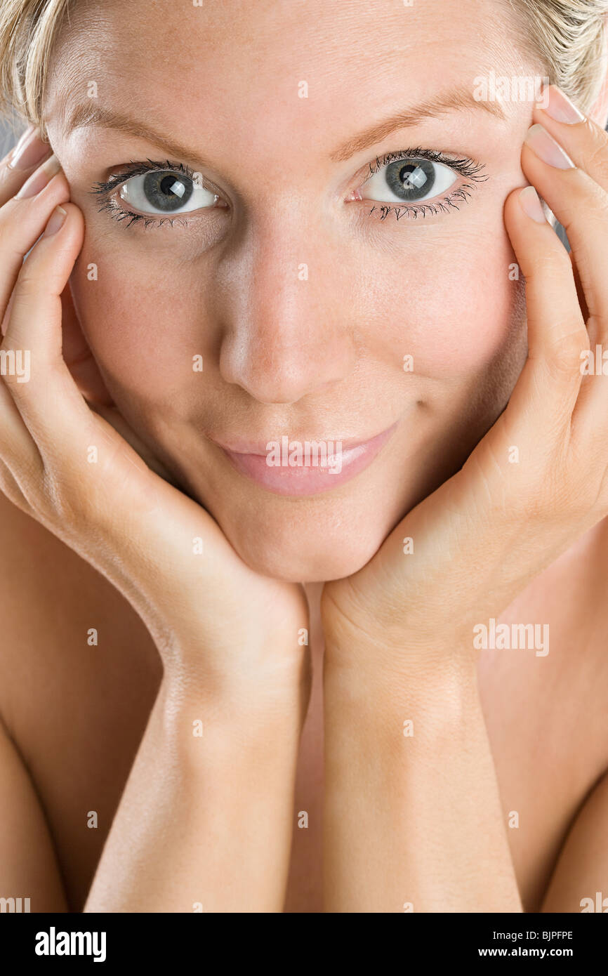 A woman touching her face Stock Photo - Alamy