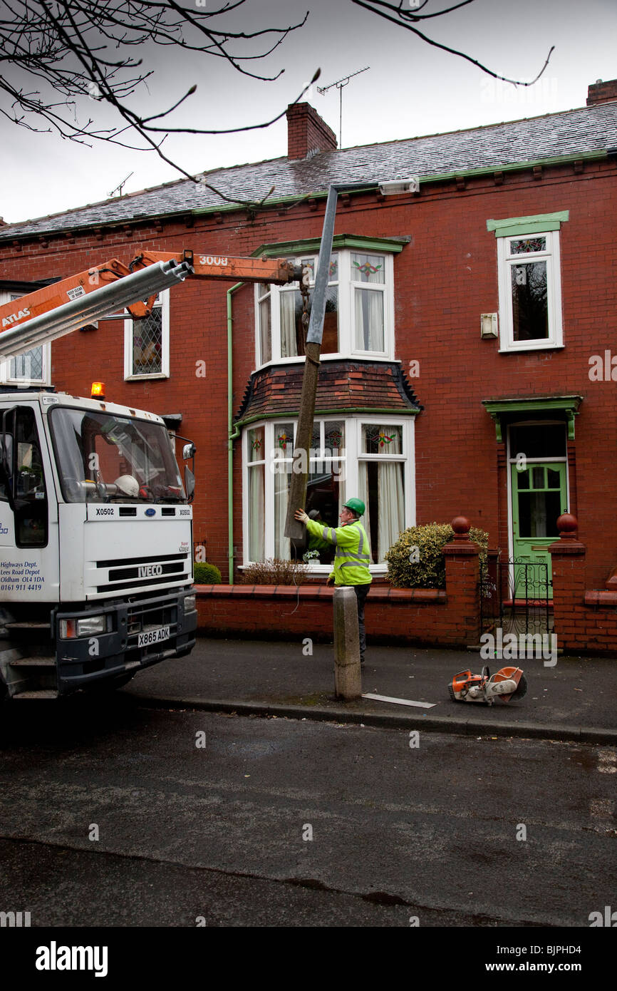 Council worker cutting down a concrete lamp post Stock Photo - Alamy