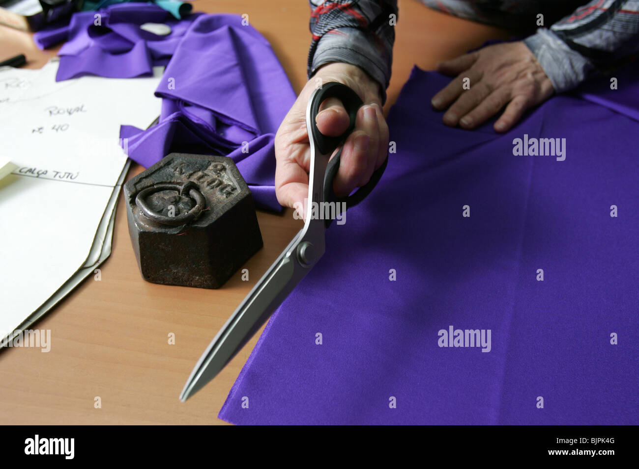 Woman`s hand cutting fabric with a scissor Stock Photo - Alamy
