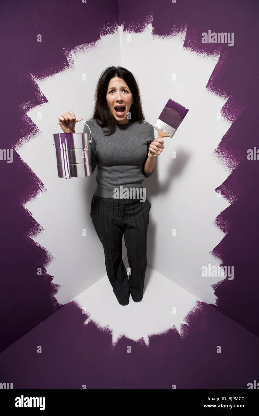 Woman sitting in a corner looking scared Stock Photo - Alamy