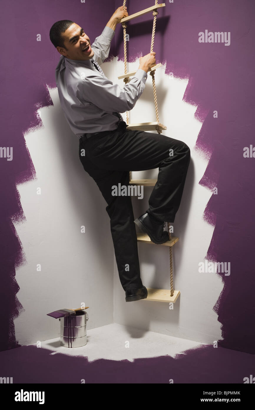 Man climbing a ladder Stock Photo - Alamy