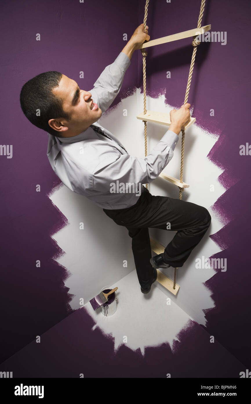 Man climbing a ladder Stock Photo - Alamy