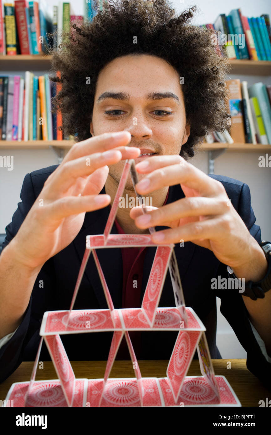 Man making a pyramid out of playing cards Stock Photo - Alamy