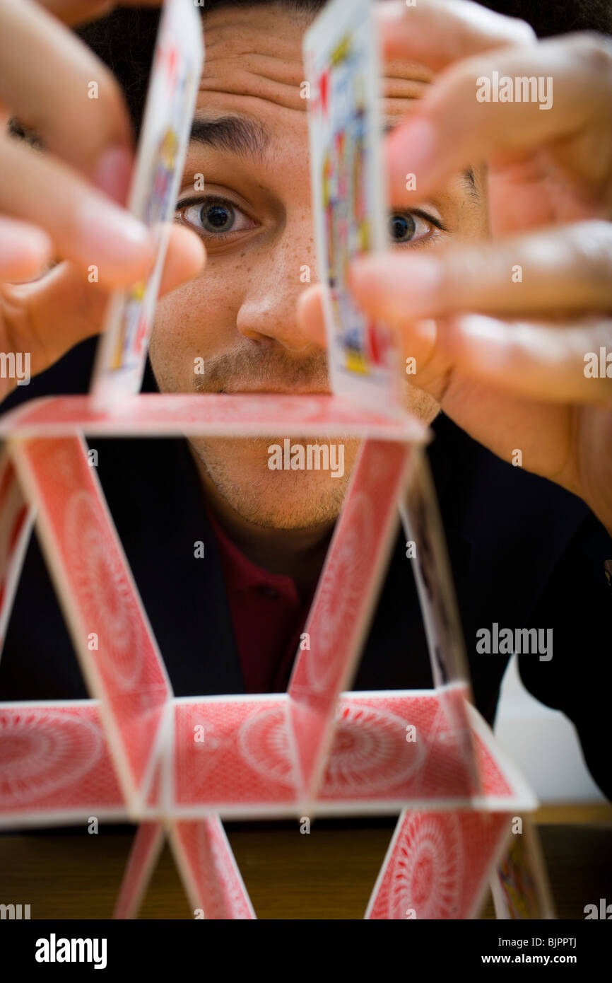 Man making a pyramid out of playing cards Stock Photo - Alamy