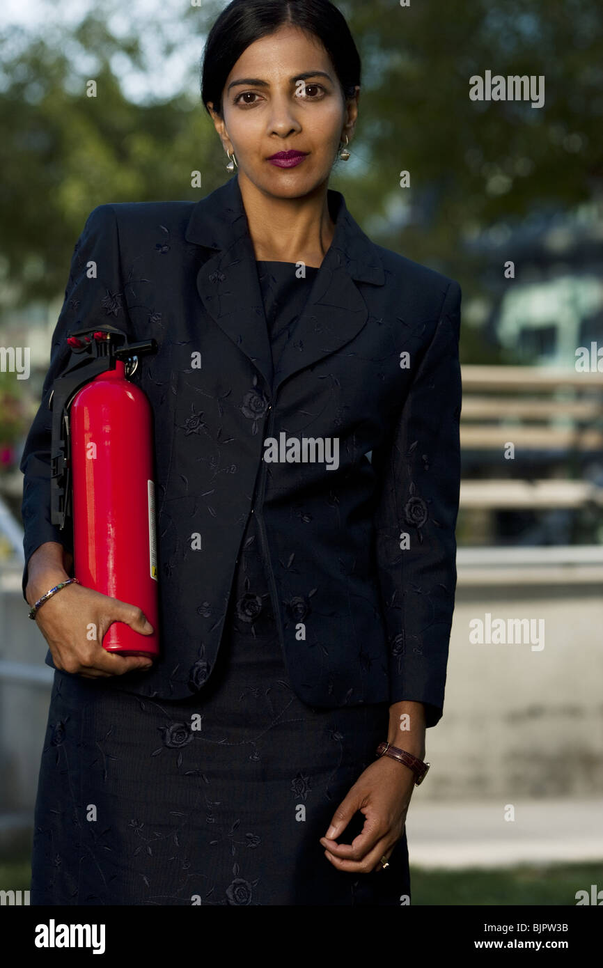 Businesswoman with fire extinguisher Stock Photo - Alamy