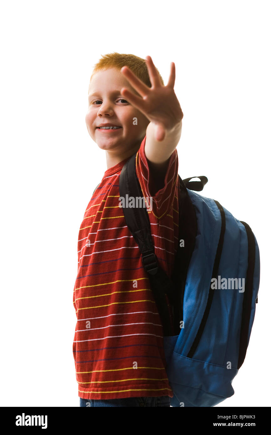 Boy waving with school bus in background Stock Photo - Alamy
