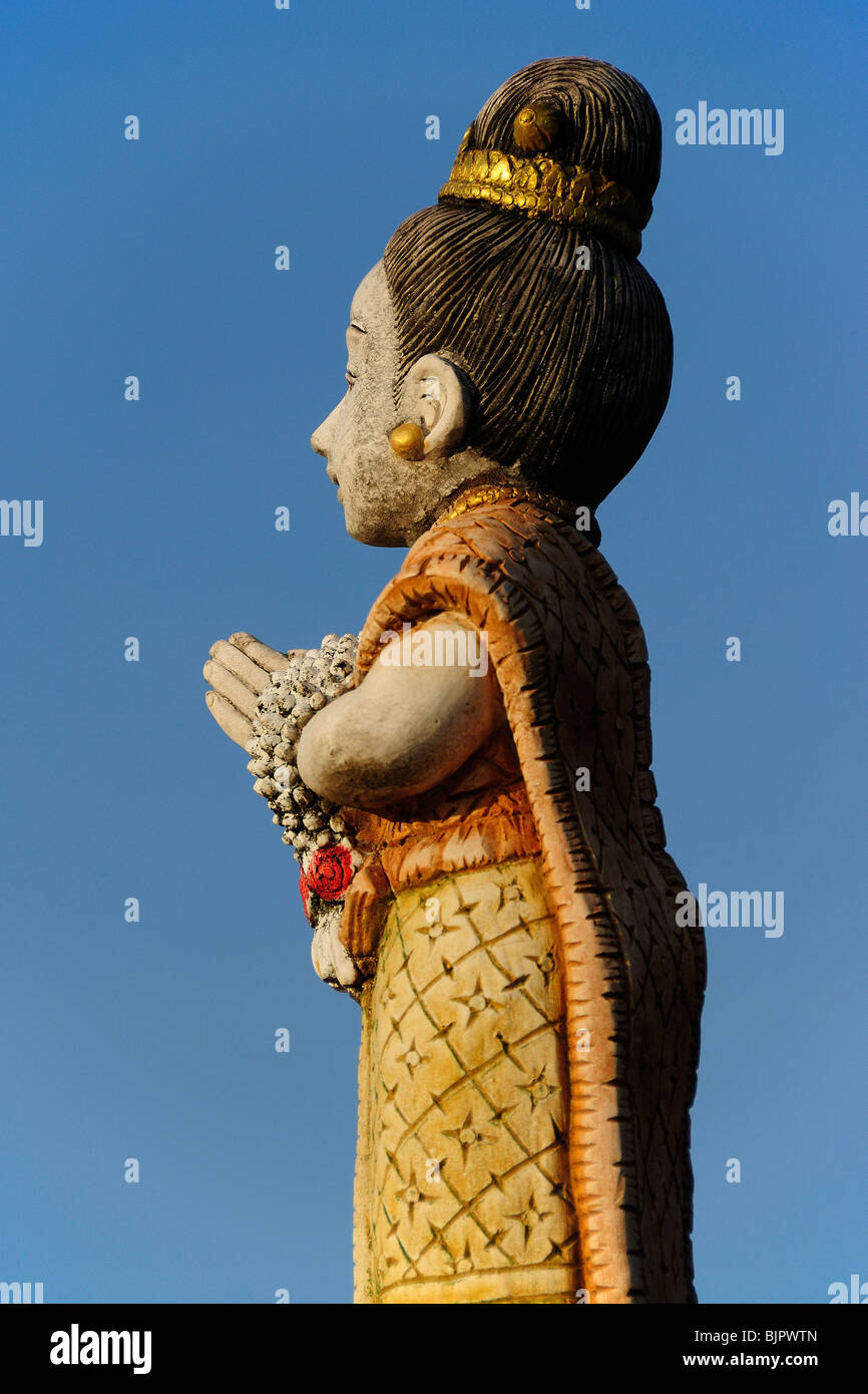 Wooden statue of a woman praying in Thailand Stock Photo - Alamy