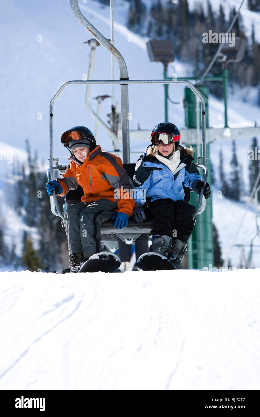 Two kids getting off a chairlift Stock Photo - Alamy