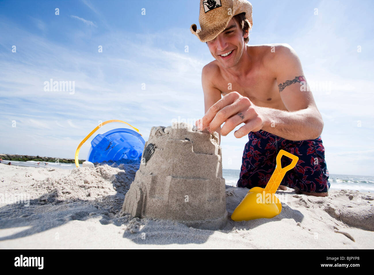 Man building a sand castle at the beach Stock Photo - Alamy