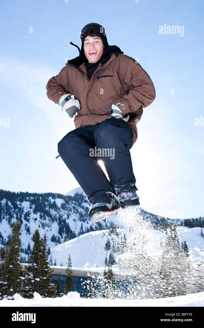 Teenage boy jumping outside in the snow Stock Photo - Alamy