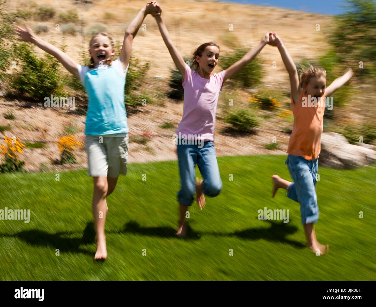 Three girl friends running outside Stock Photo - Alamy