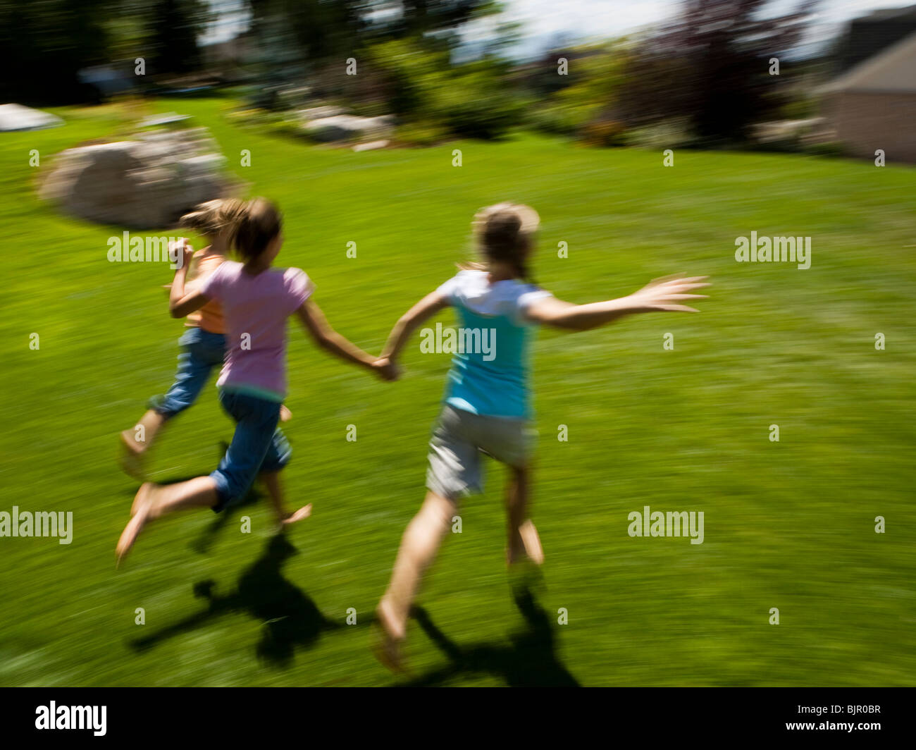 Three girl friends running outside Stock Photo - Alamy
