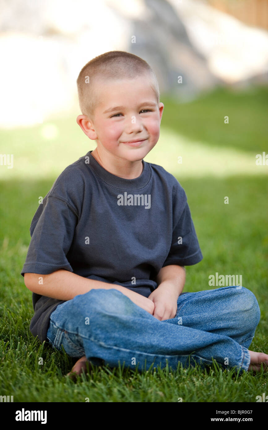 Boy sitting outside Stock Photo - Alamy