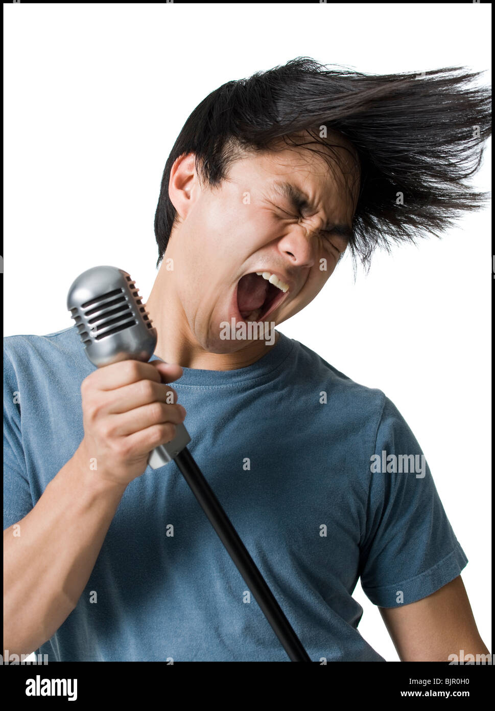 Man rocking out with mic stand Stock Photo - Alamy