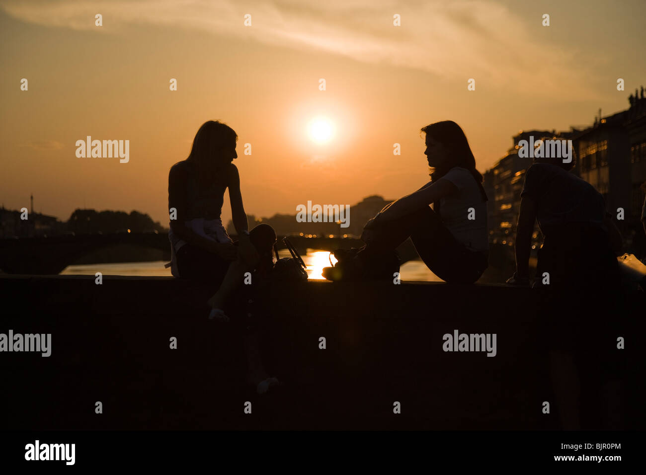 Two people talking at sunset Stock Photo - Alamy
