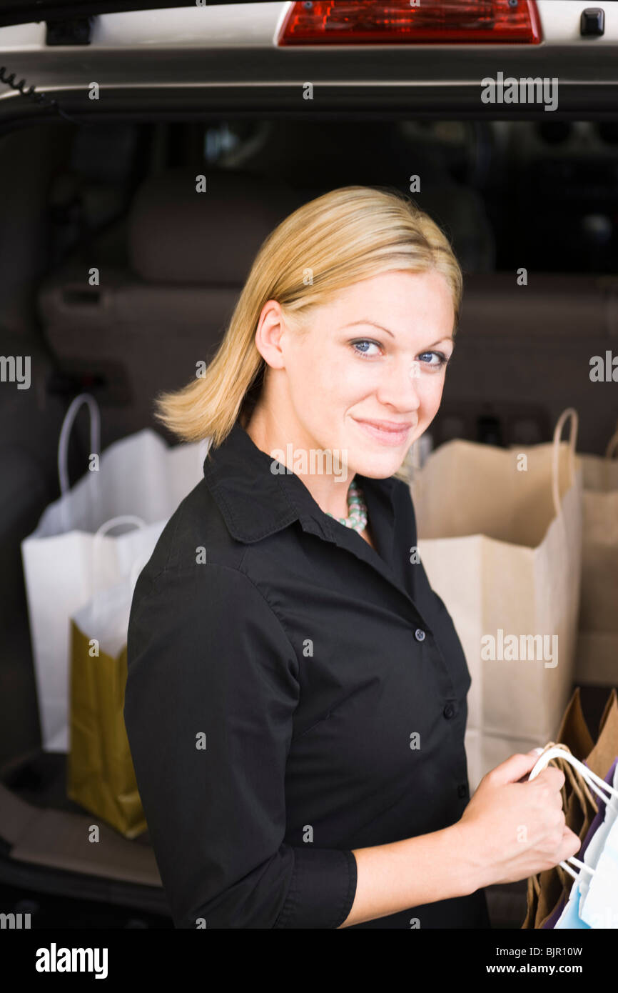 Woman loading bags into vehicle Stock Photo - Alamy