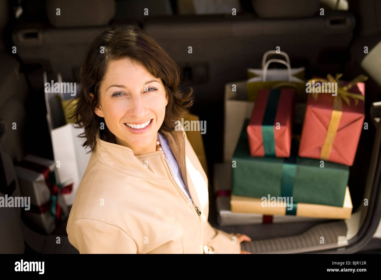 Woman loading gifts into vehicle Stock Photo - Alamy