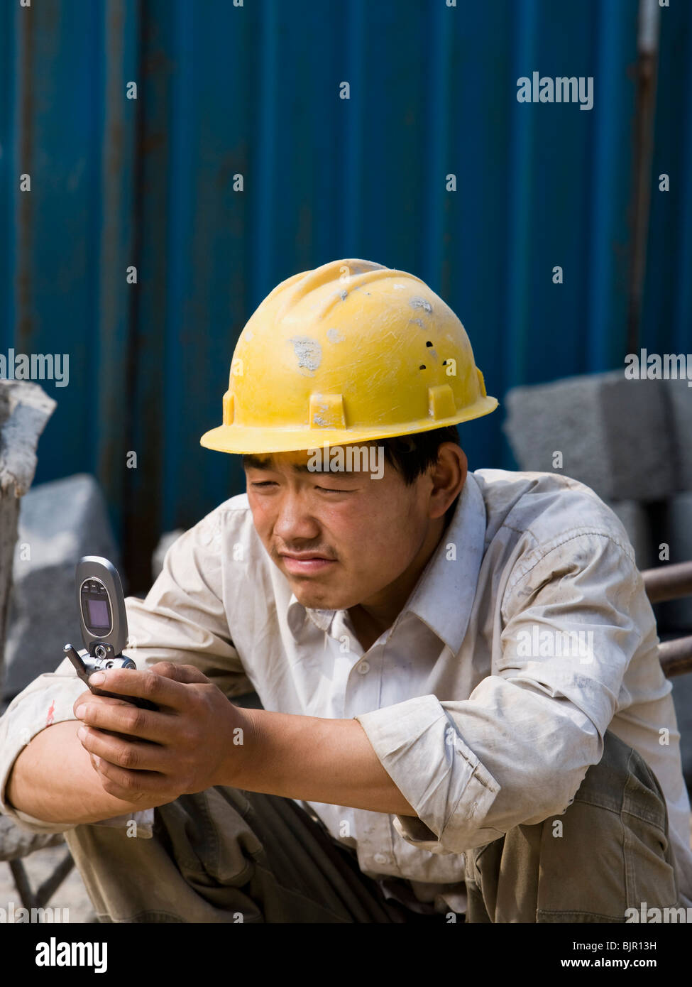 Construction worker looking at his cell phone Stock Photo - Alamy