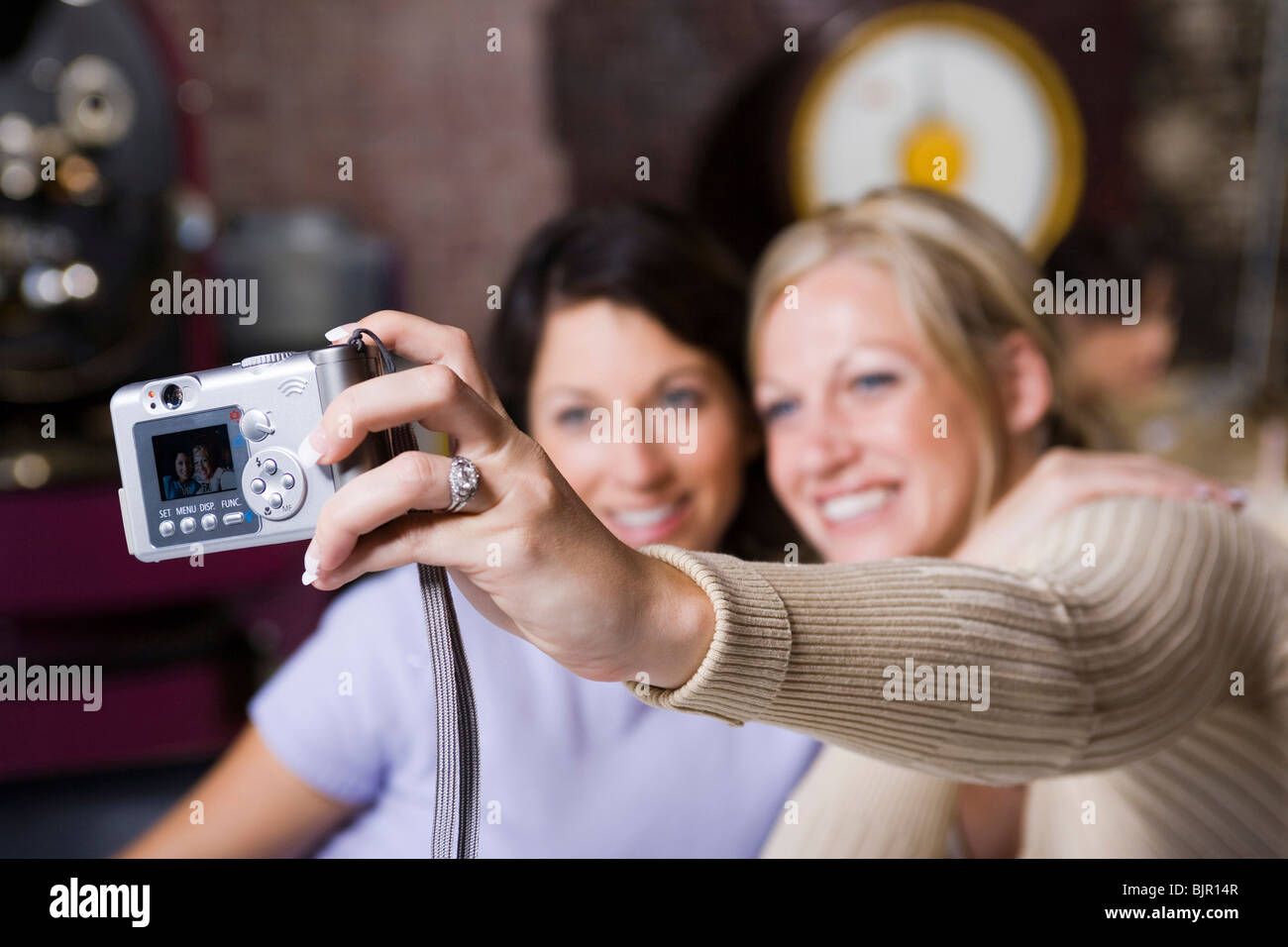Two girl friends using a digital camera Stock Photo - Alamy