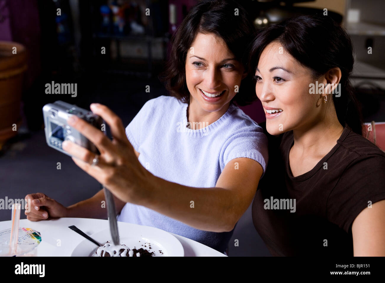 Two girl friends using a digital camera Stock Photo - Alamy