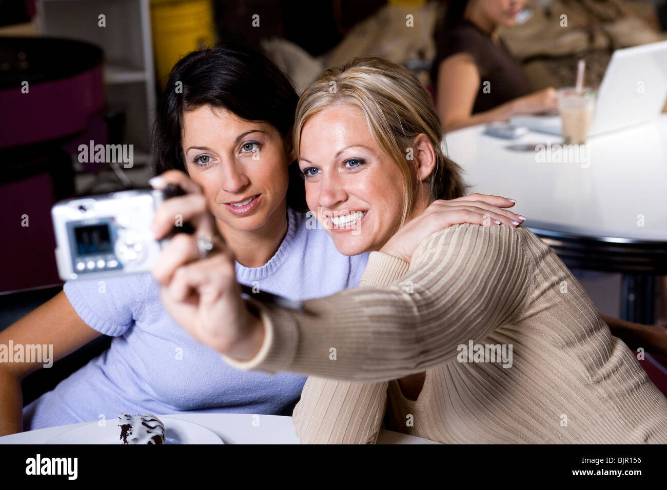 Two girl friends using a digital camera Stock Photo - Alamy