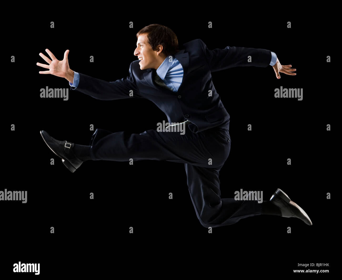 Young man running in a suit Stock Photo - Alamy