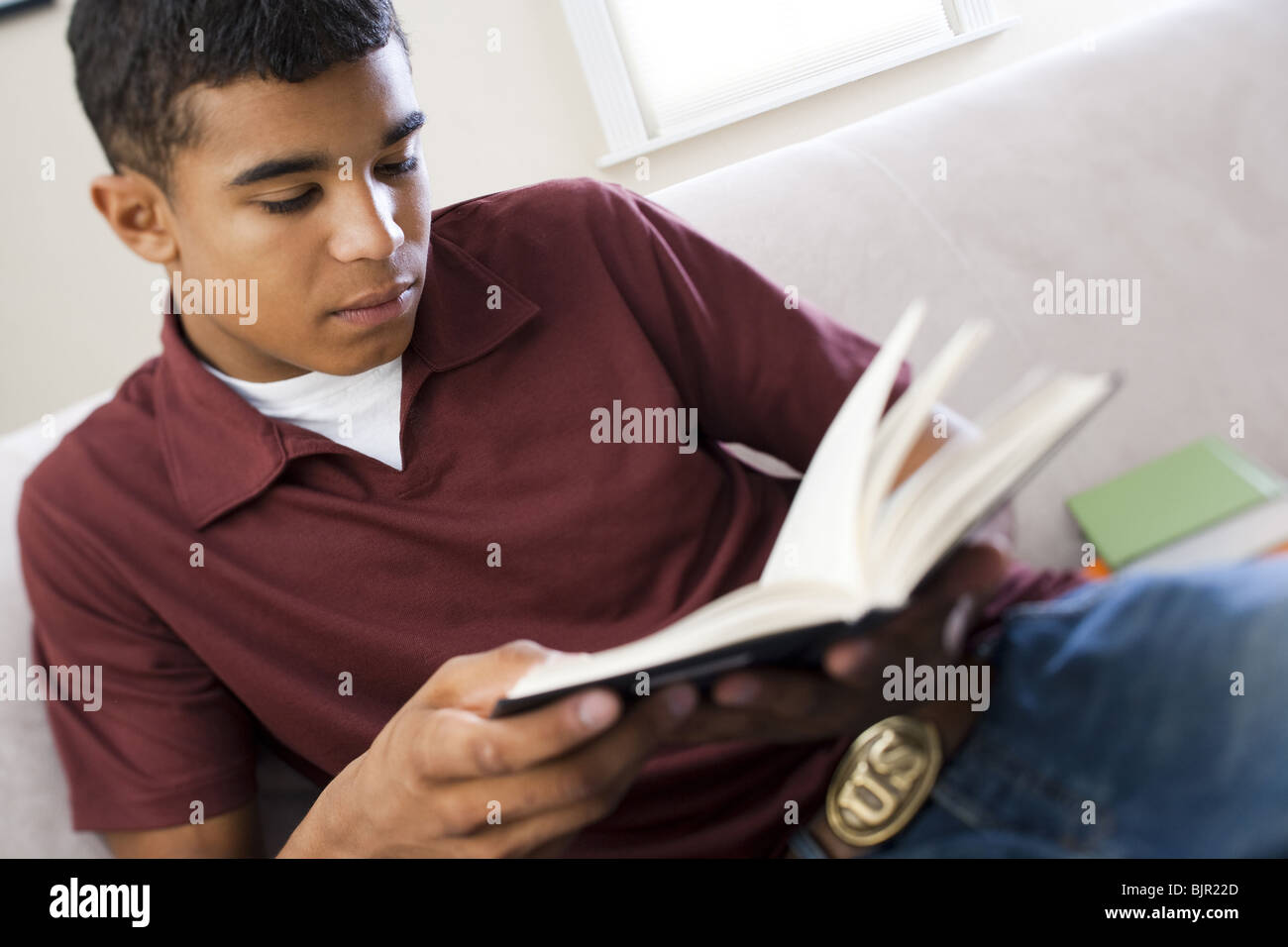 Teenage boy reading a book Stock Photo - Alamy
