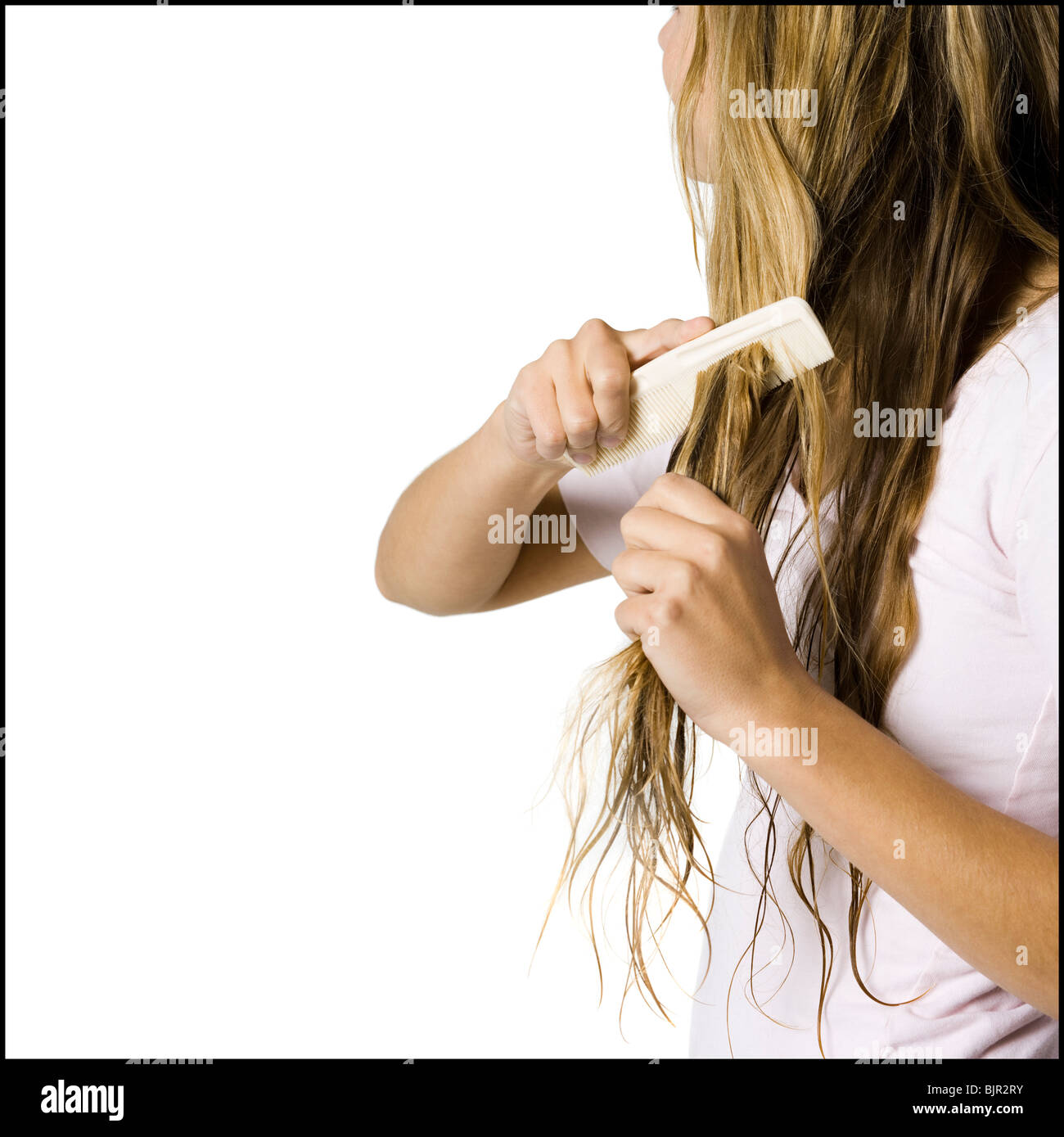 Young woman combing hair Stock Photo - Alamy