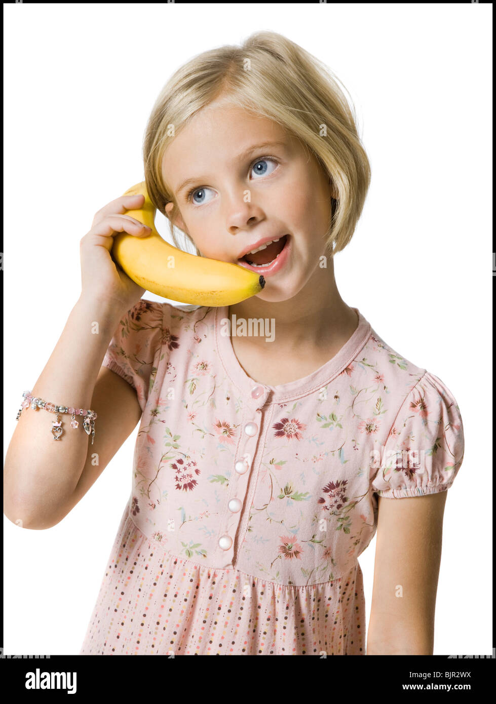 Young girl talking on a banana Stock Photo - Alamy