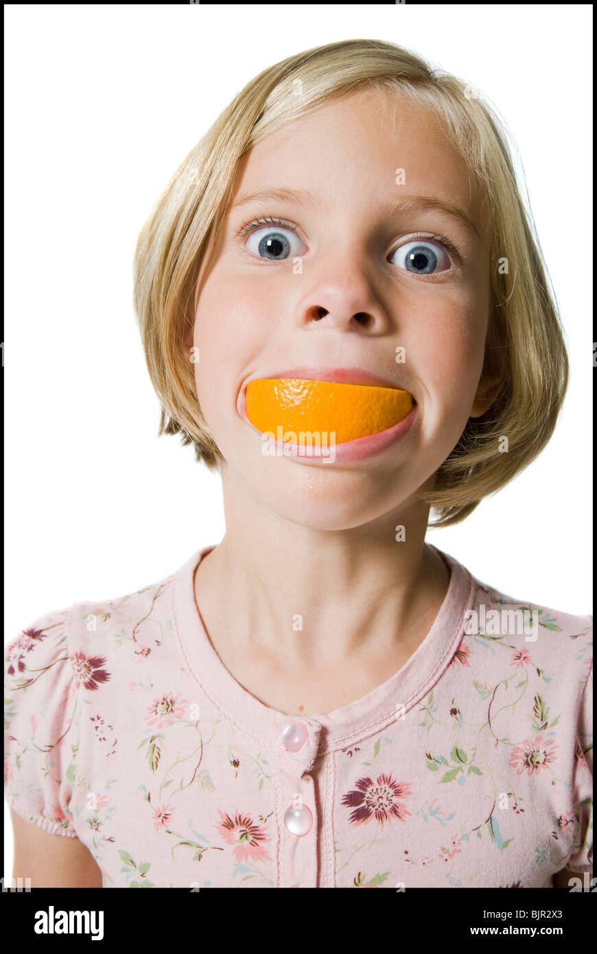 Young girl with an orange smile Stock Photo - Alamy