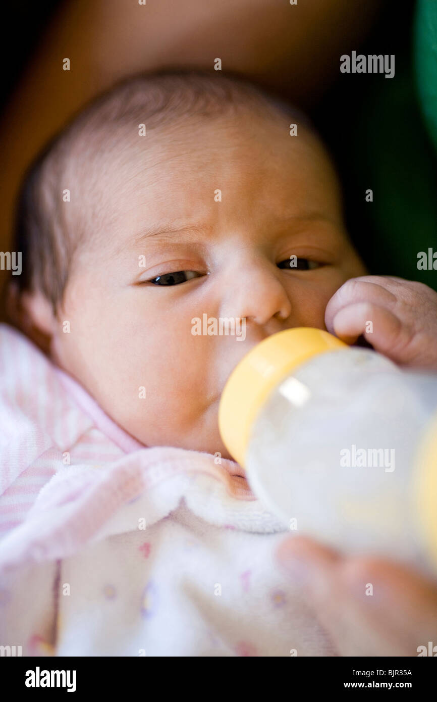 Girl feeding baby a bottle Stock Photo - Alamy