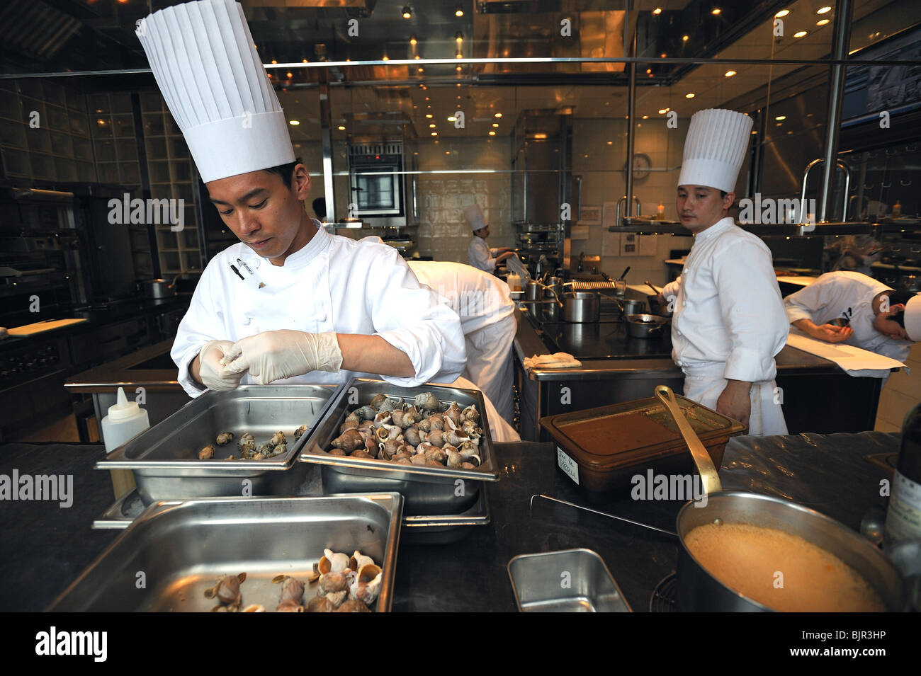 Unidentified junior chefs work in the kitchen of Beige Alain Ducasse ...