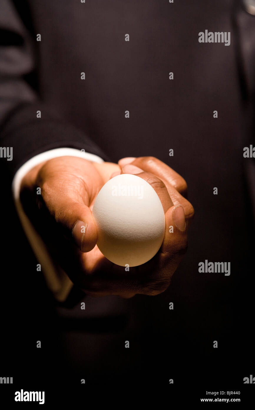 Hand holding egg Stock Photo - Alamy