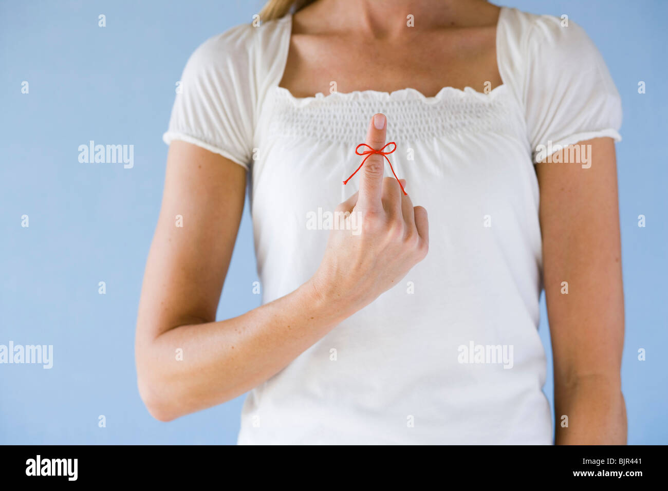 Woman with a red string tied on her finger Stock Photo - Alamy