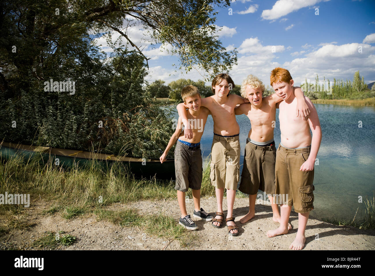 four boys playing by a lake Stock Photo - Alamy