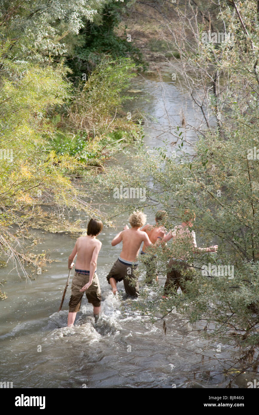 four boys crossing a river Stock Photo - Alamy