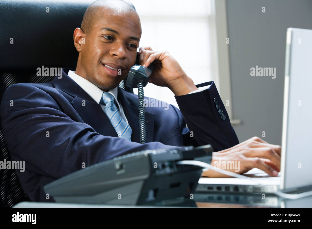 Businessman on laptop and on the phone Stock Photo - Alamy