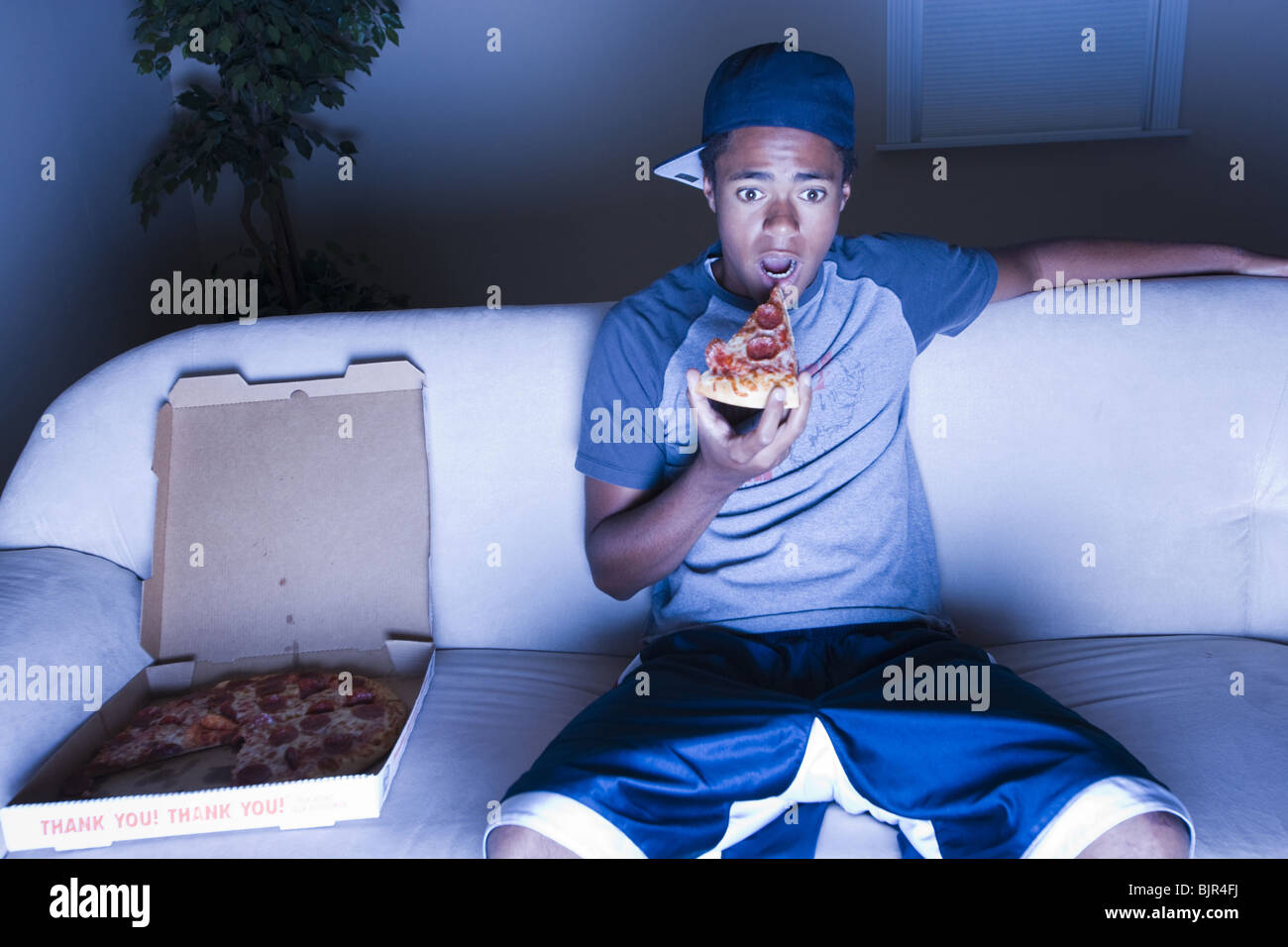 Teenage boy eating popcorn Stock Photo - Alamy