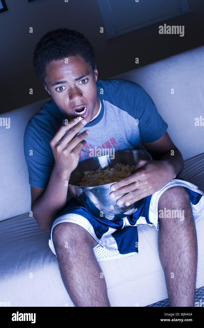 Teenage boy eating popcorn Stock Photo - Alamy