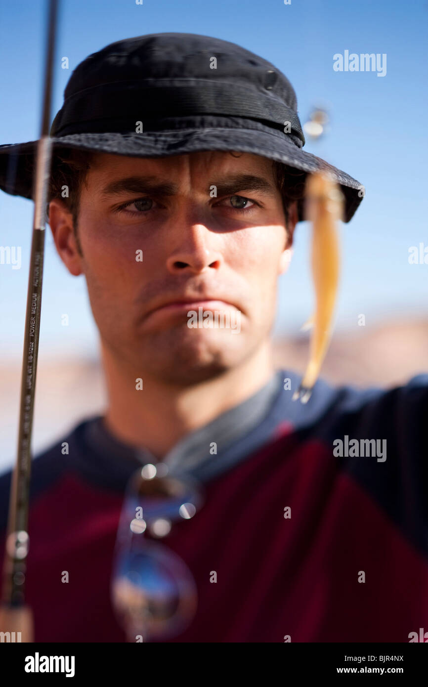 Man fishing holding up a catch Stock Photo - Alamy
