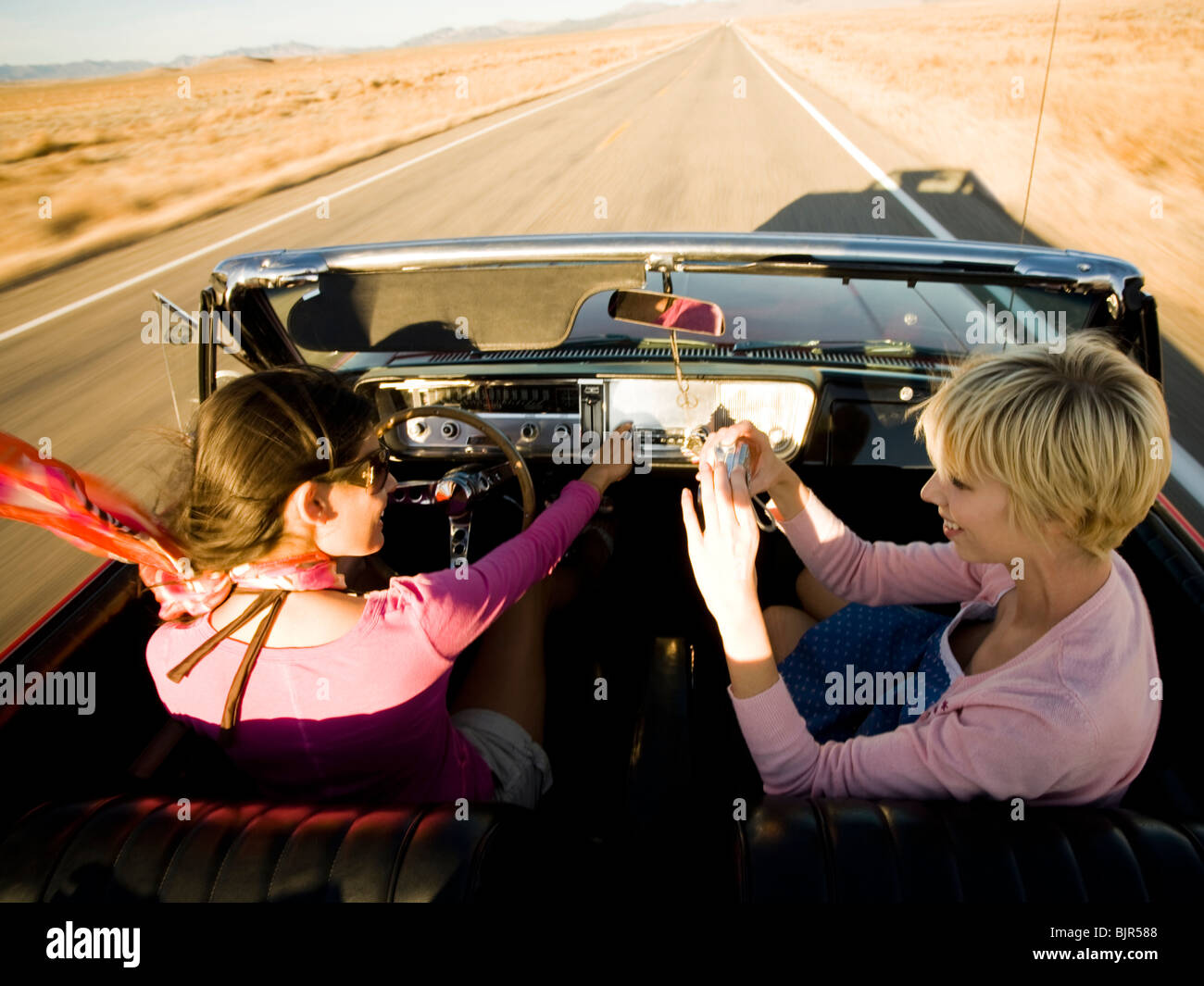 two women in a red convertible Stock Photo - Alamy
