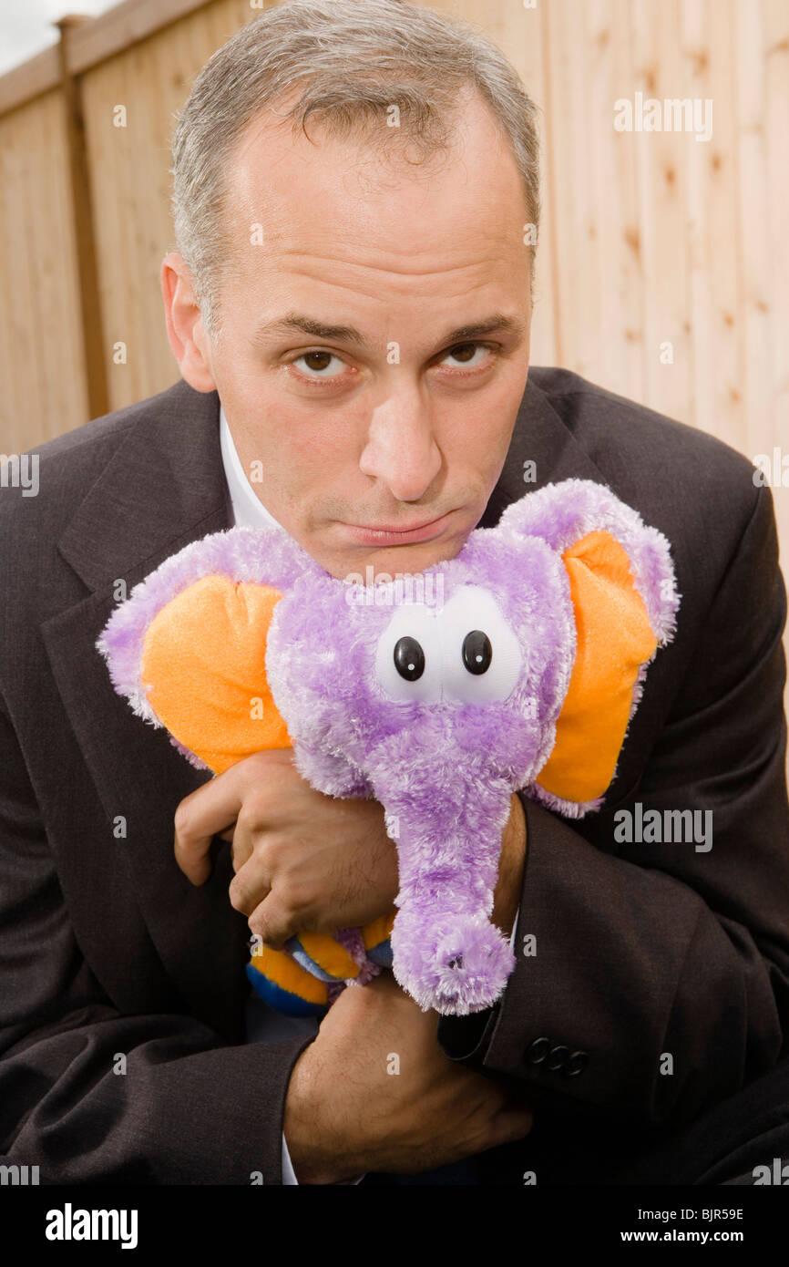 Businessman holding a plush elephant Stock Photo - Alamy