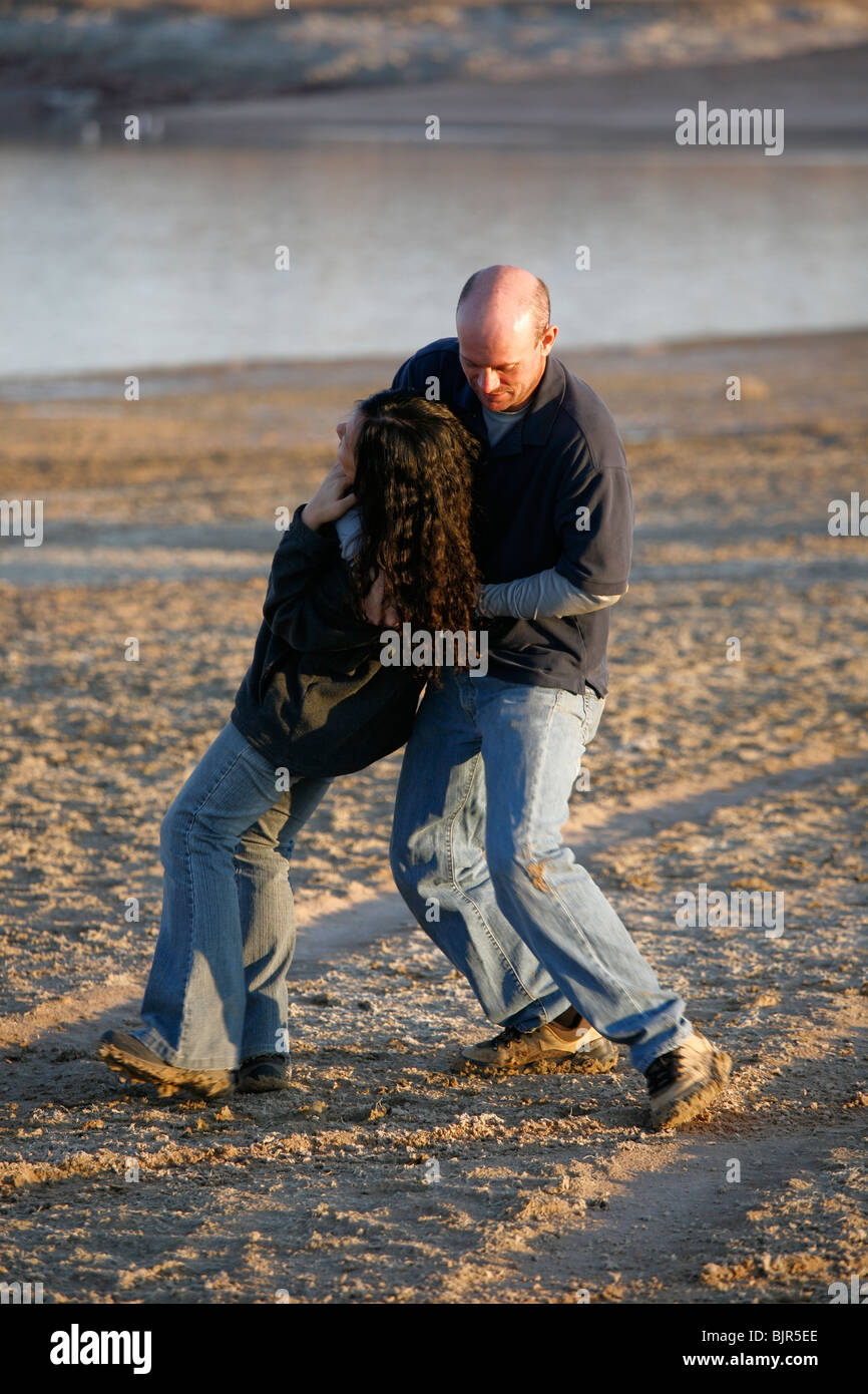Couple playing and wrestling along the shore of Lake Powell, near Utah ...