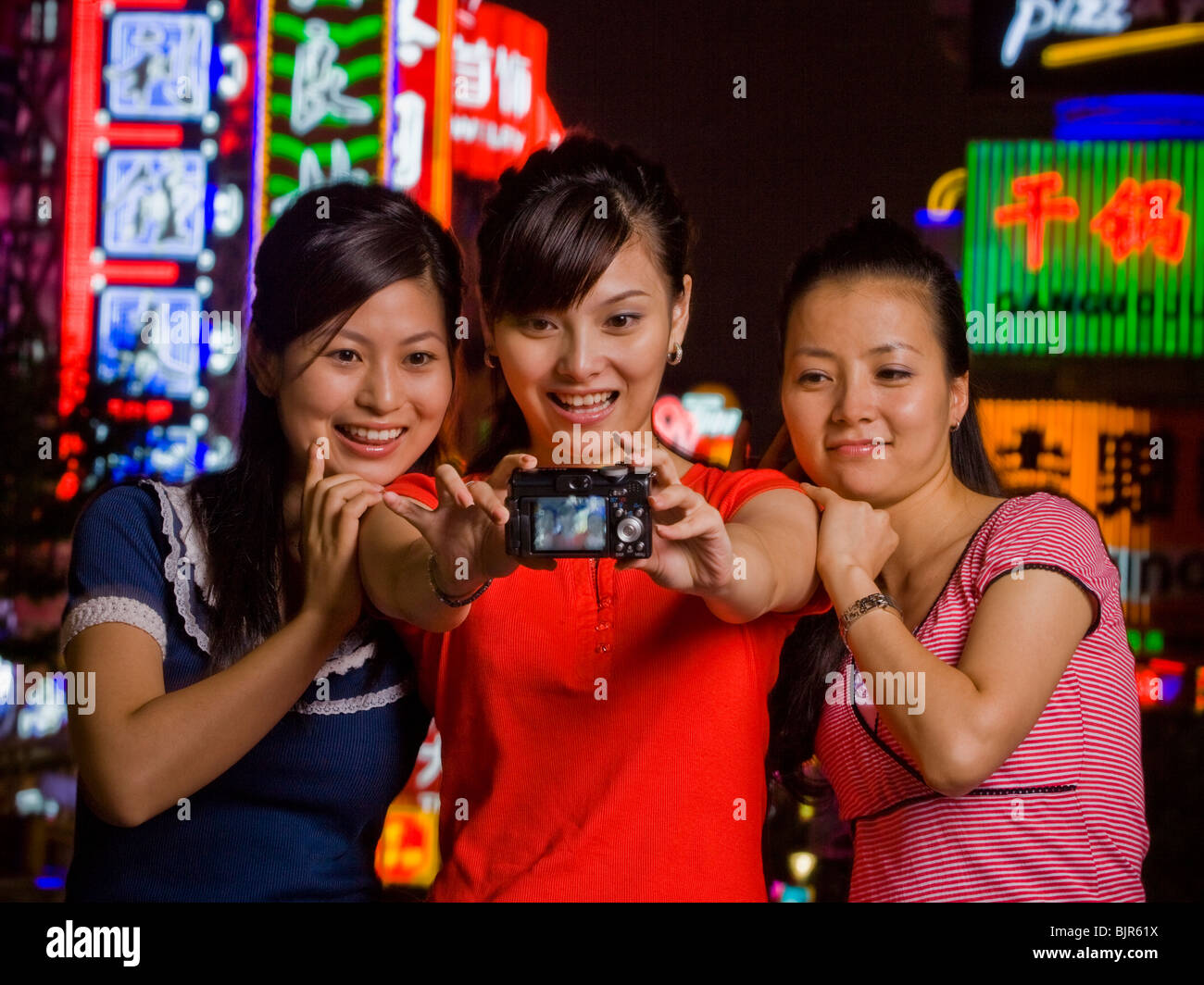 three woman with a camera Stock Photo - Alamy